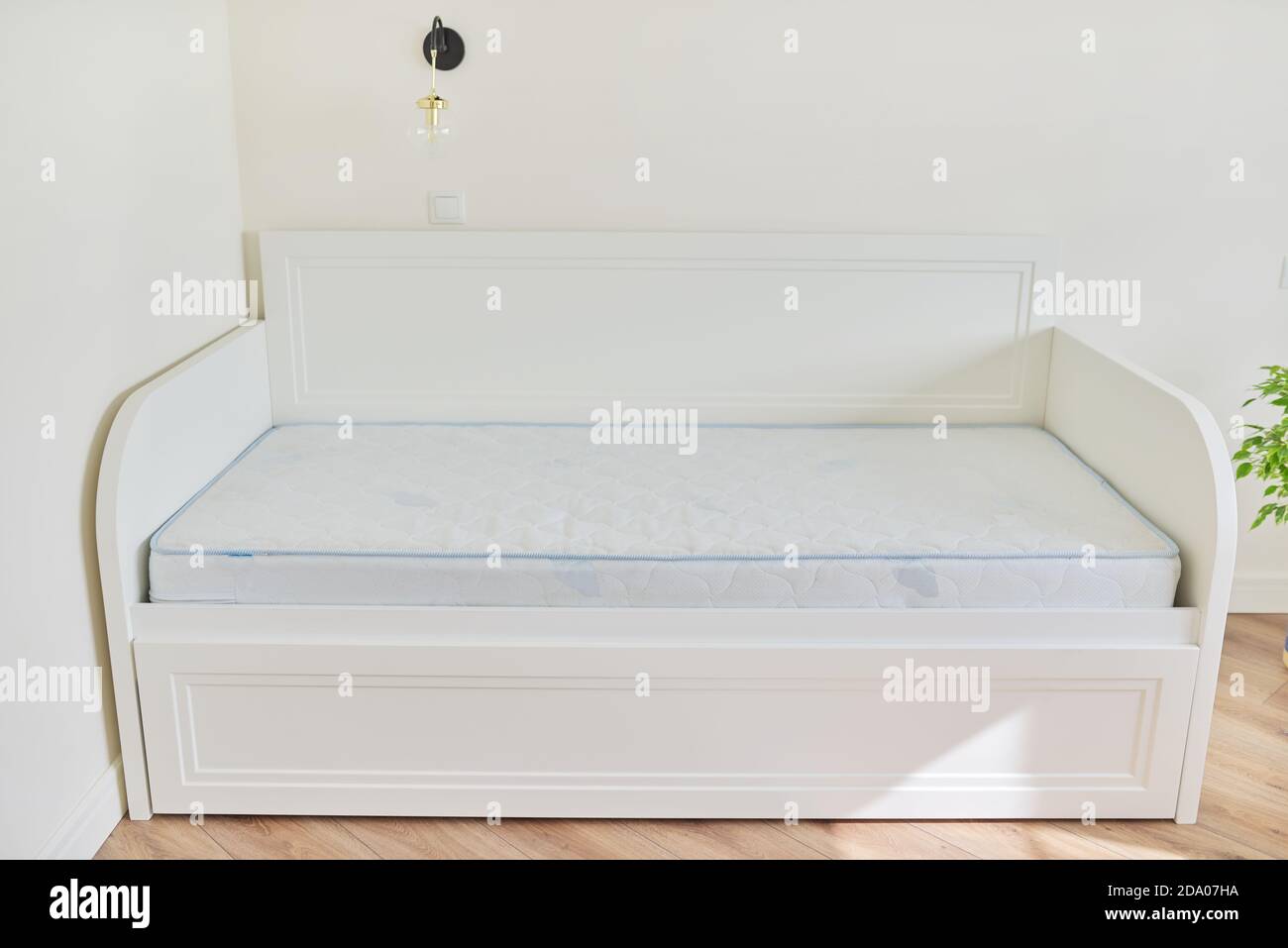 White new wooden comfortable bed with mattress for girl in empty room ...