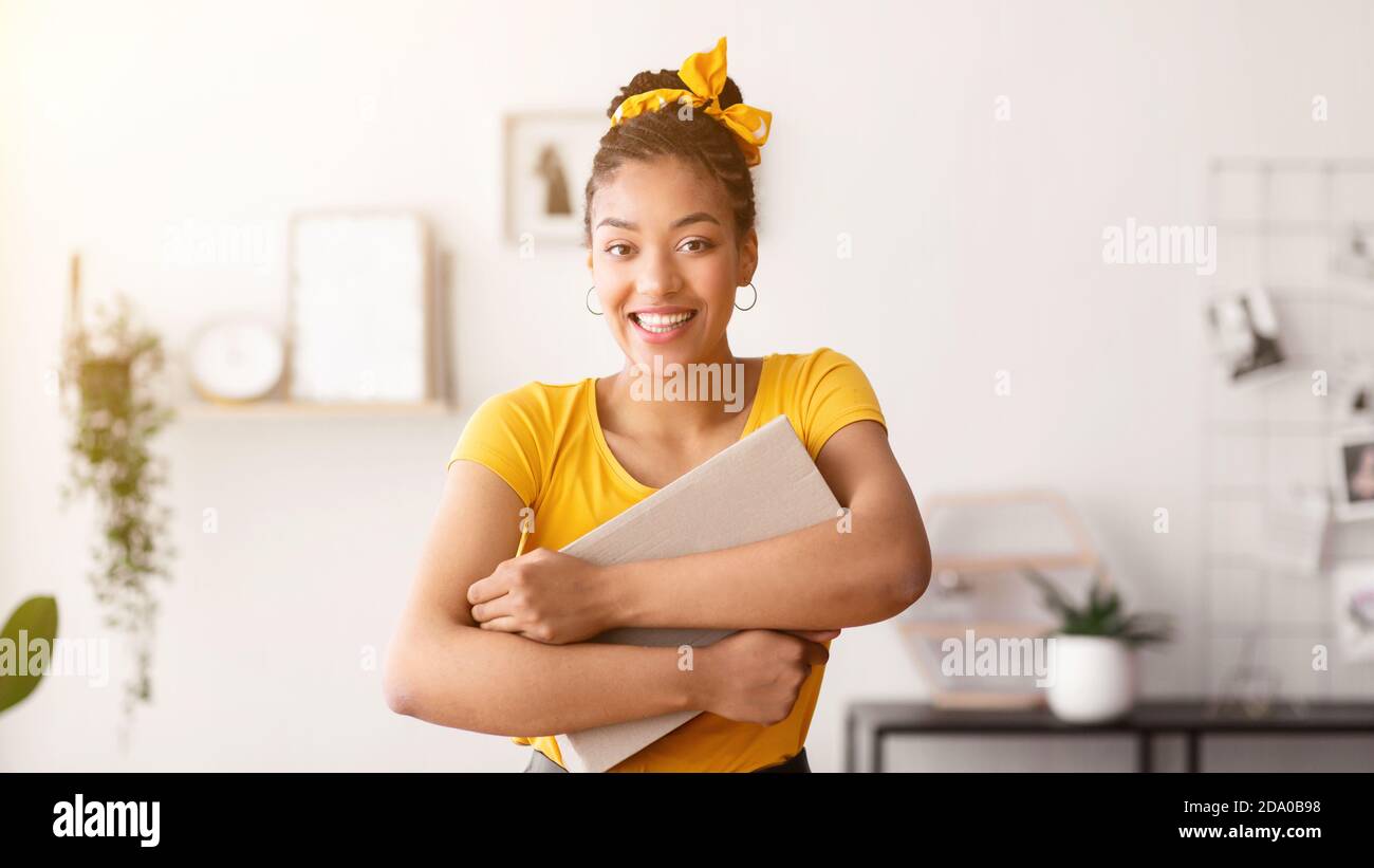 Excited black lady hugging and embracing carton box Stock Photo - Alamy