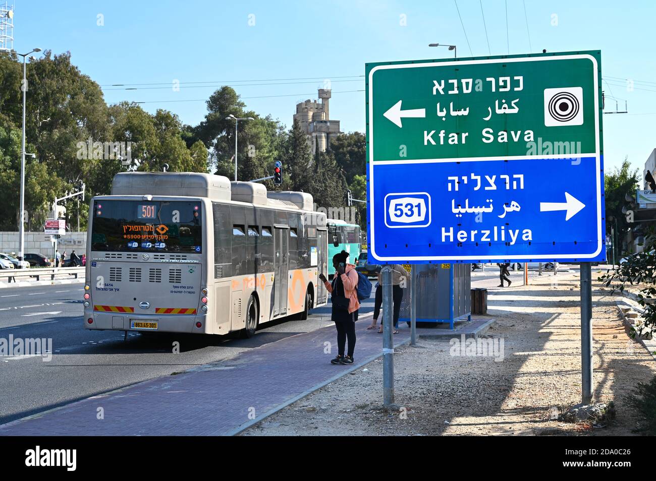 Direction sign and a bus stop Stock Photo - Alamy