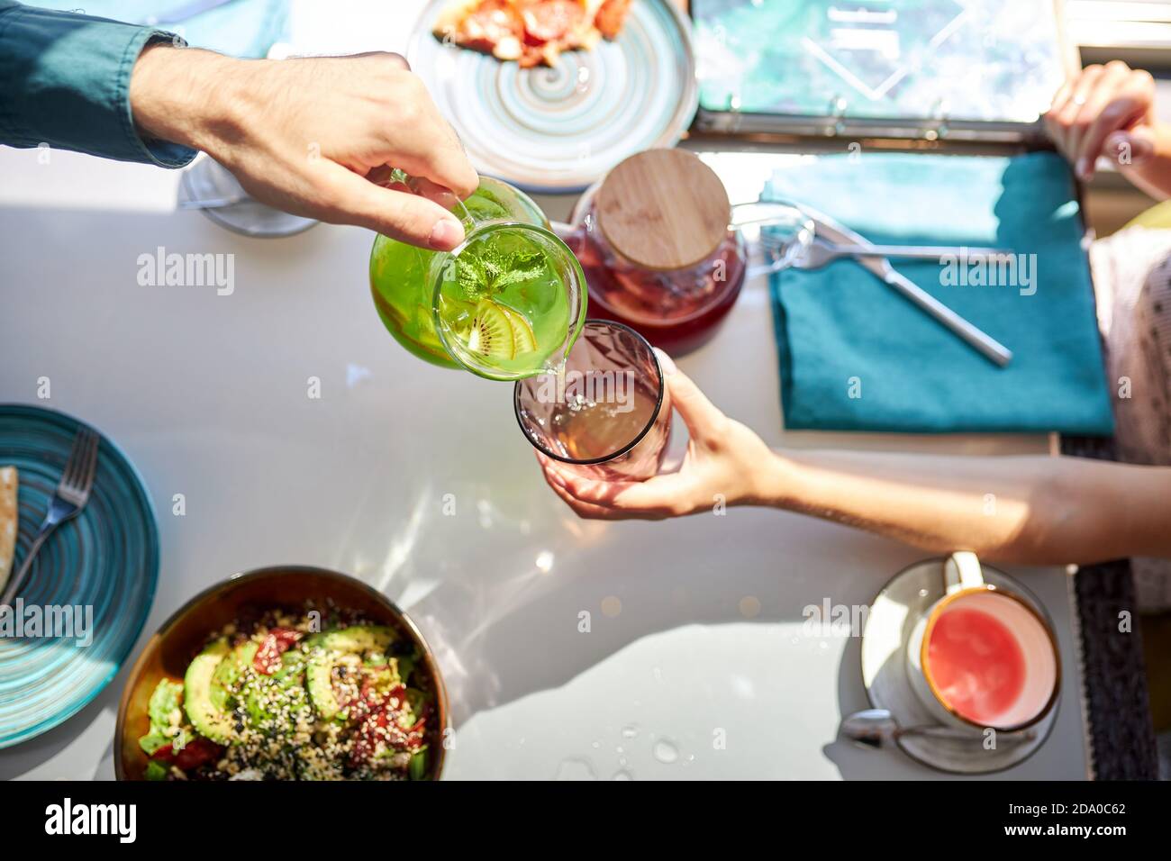 top view on people pouring beverage in glass, young men and women in ...