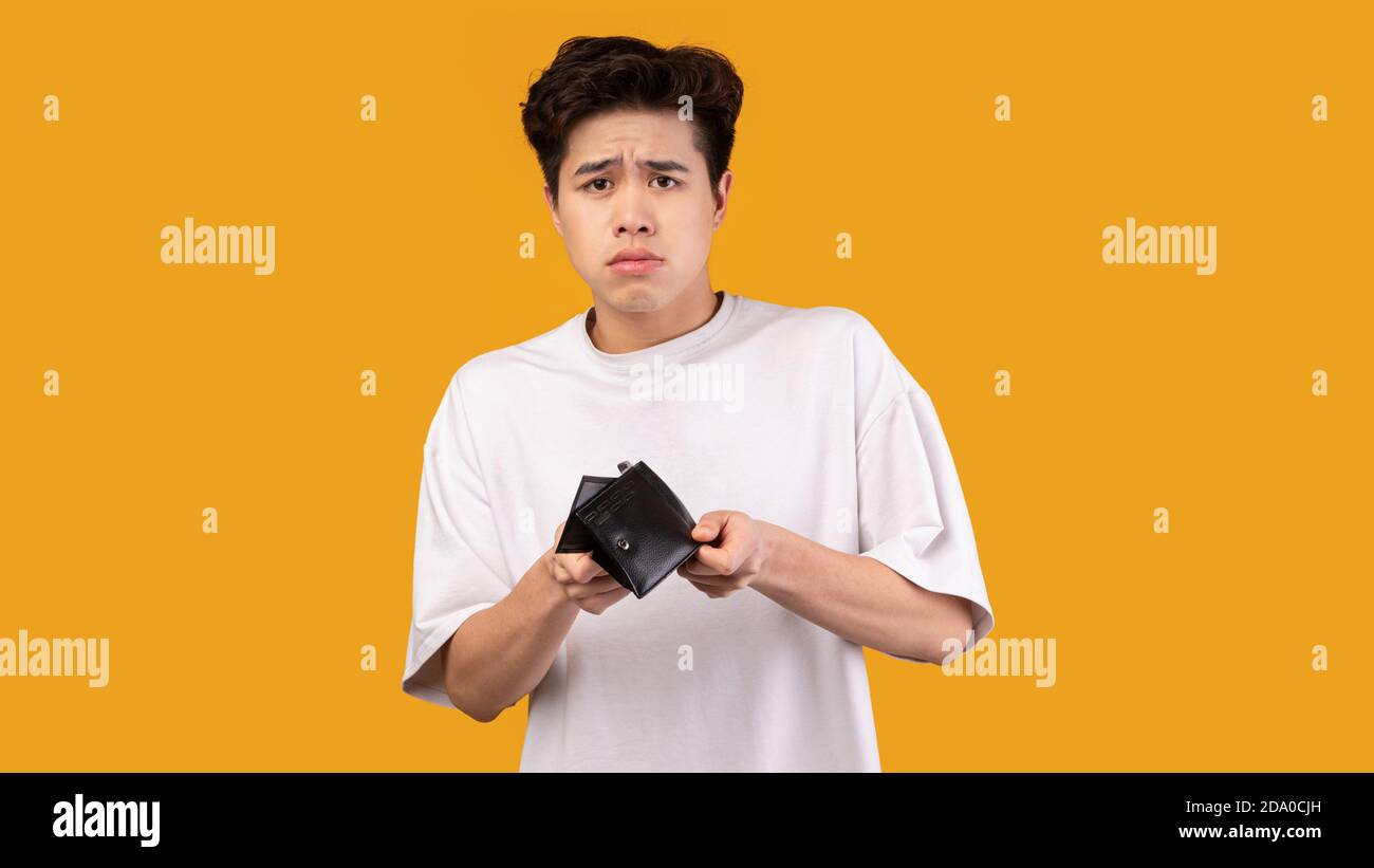 Portrait of asian guy showing his empty wallet Stock Photo - Alamy