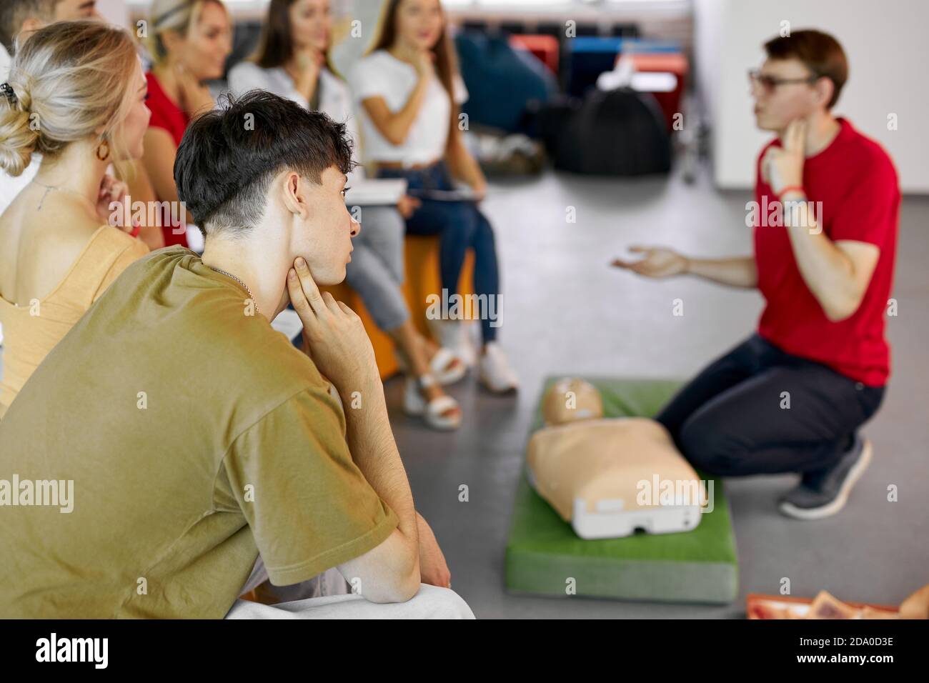 group of young caucasian people learning how to safe a life sitting ...