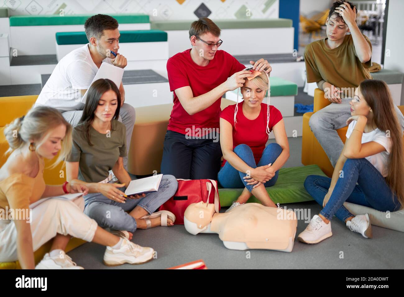 group of young caucasian people practice treating a patient by bandages ...