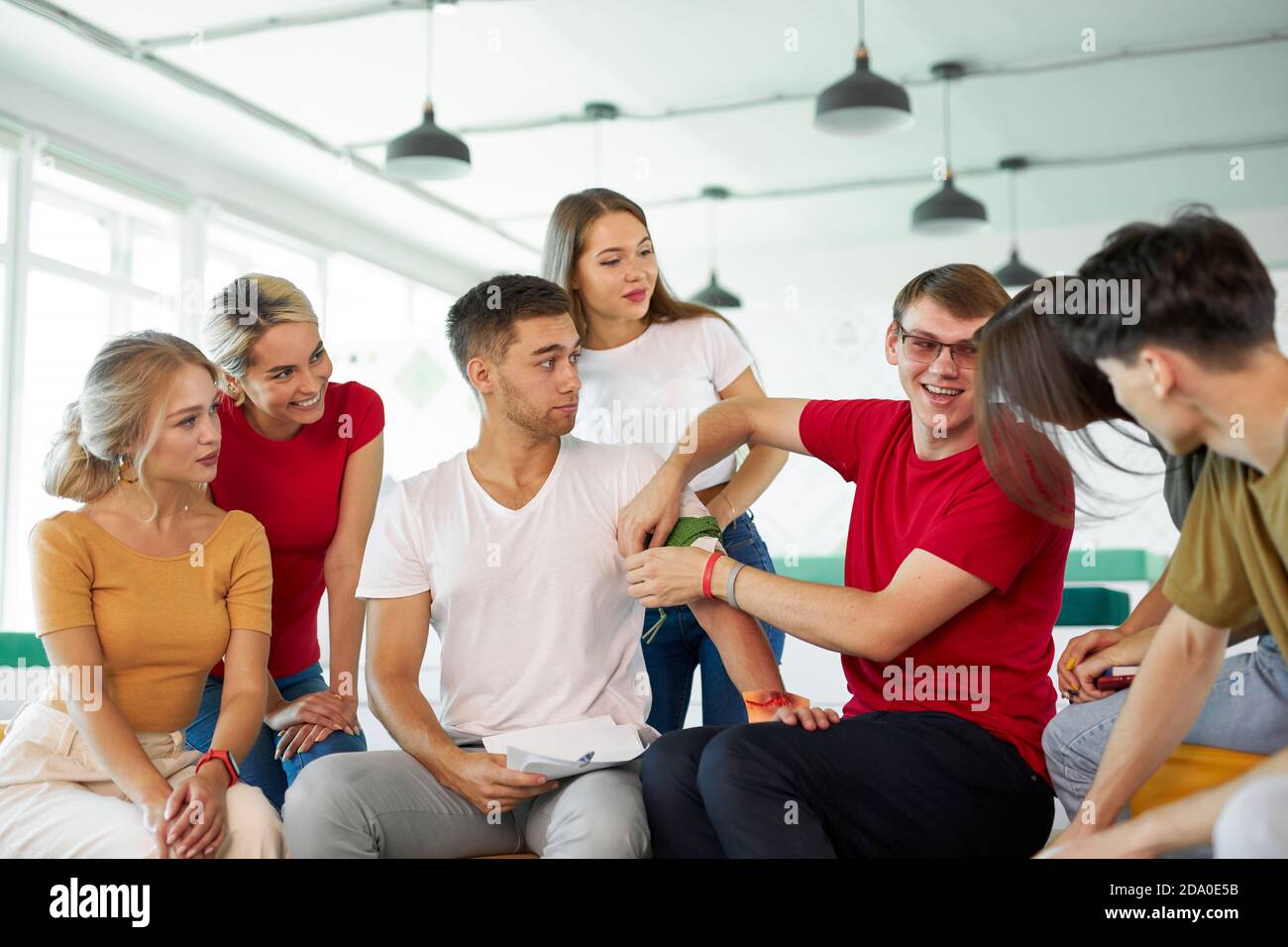 group of young caucasian people practice treating a patient by bandages ...