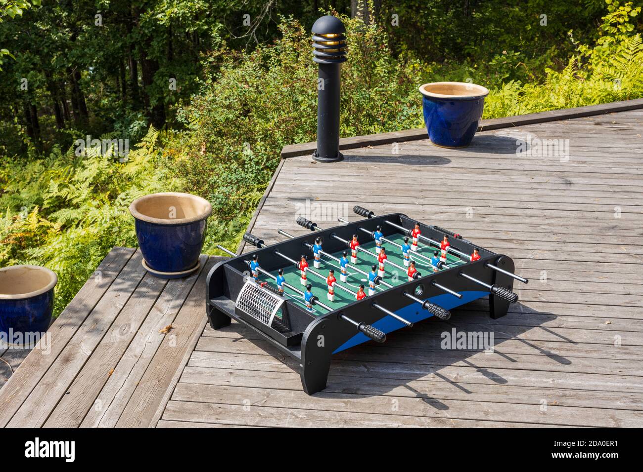 Close up view of old table football game on wooden patio. Home games ...