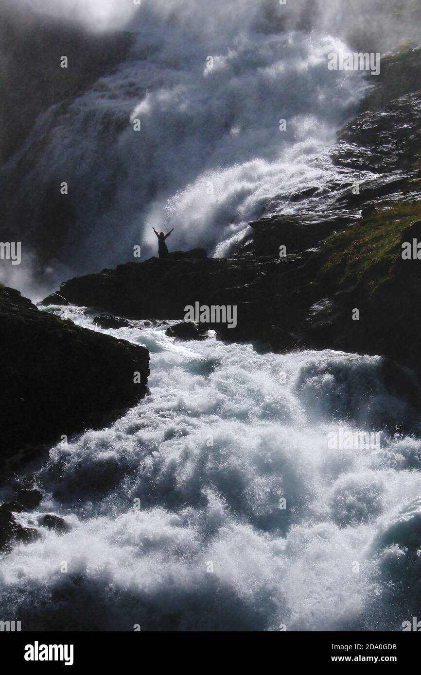 Norway. Girl dancing under huge waterfall Stock Photo - Alamy