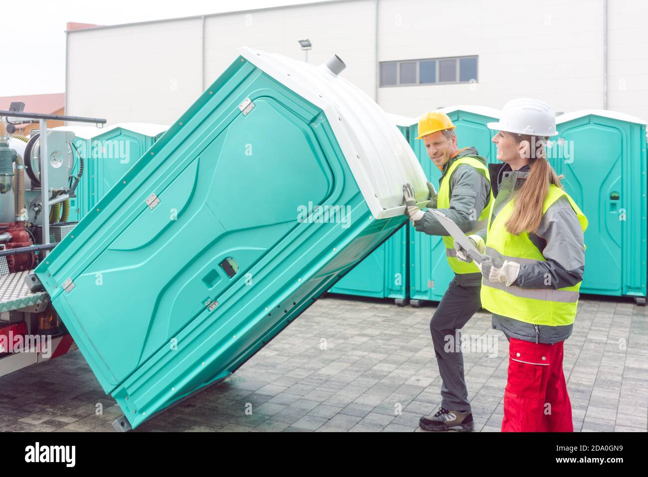 Worker loading portable toilets on truck Stock Photo - Alamy