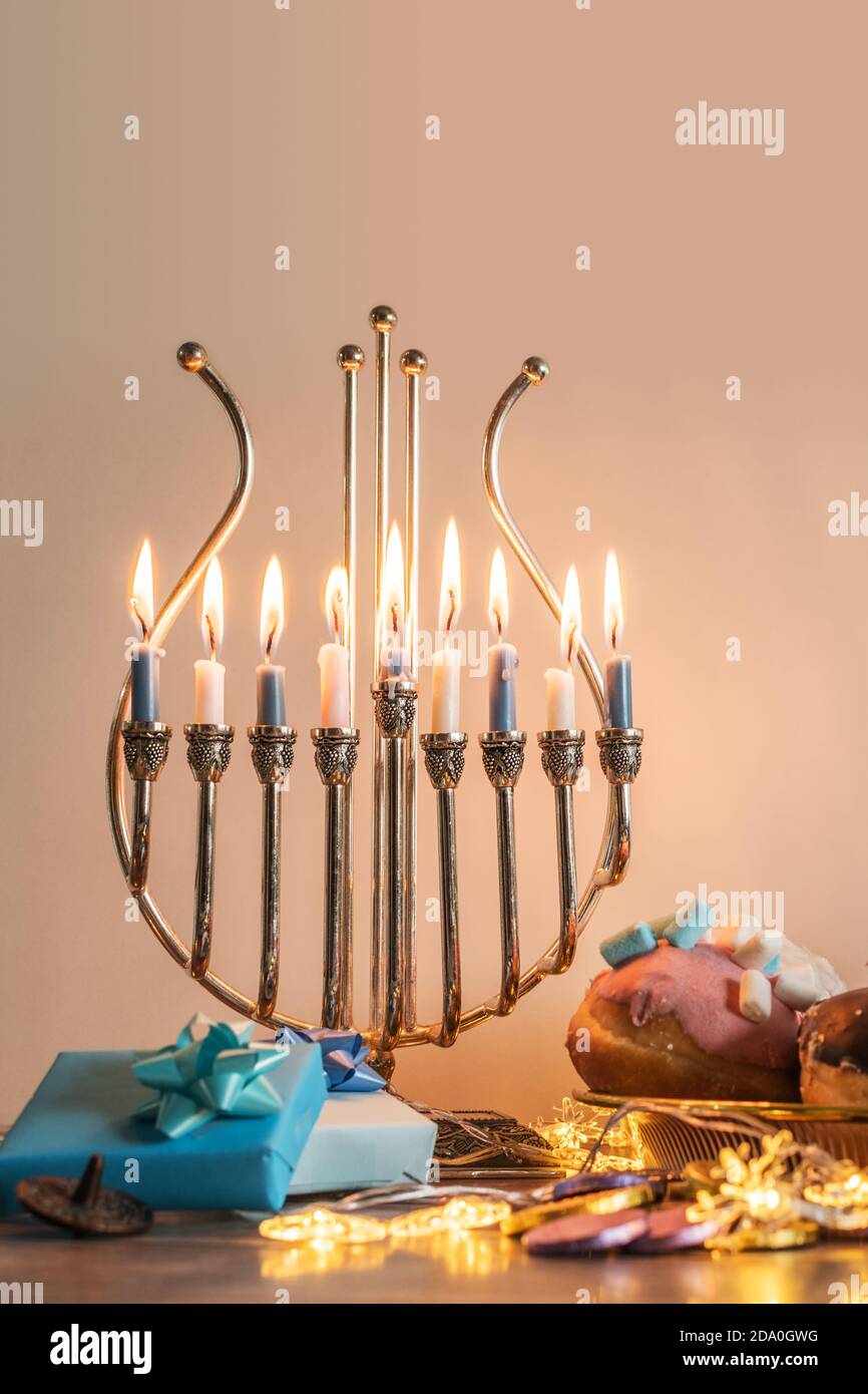 Beautiful shot of a burning Menorah lampstand next to pastry in ...