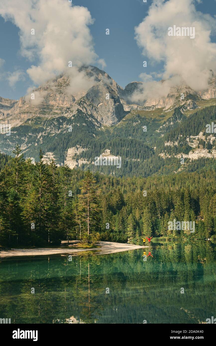 Picturesque view of calm clear pond surrounded by evergreen woods and ...