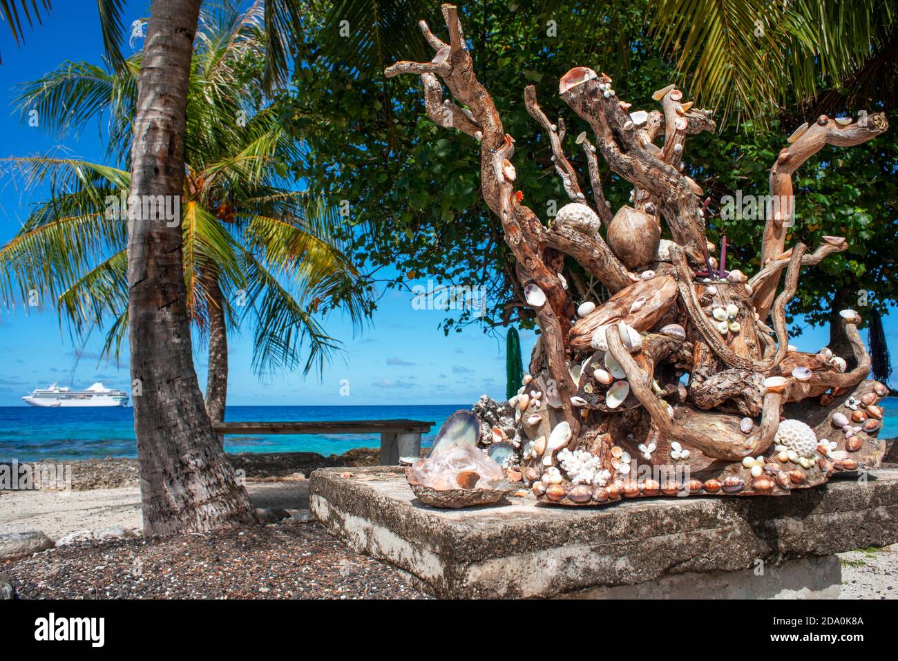 A sculpture with shells on a railing overlooking a tropical lagoon on ...