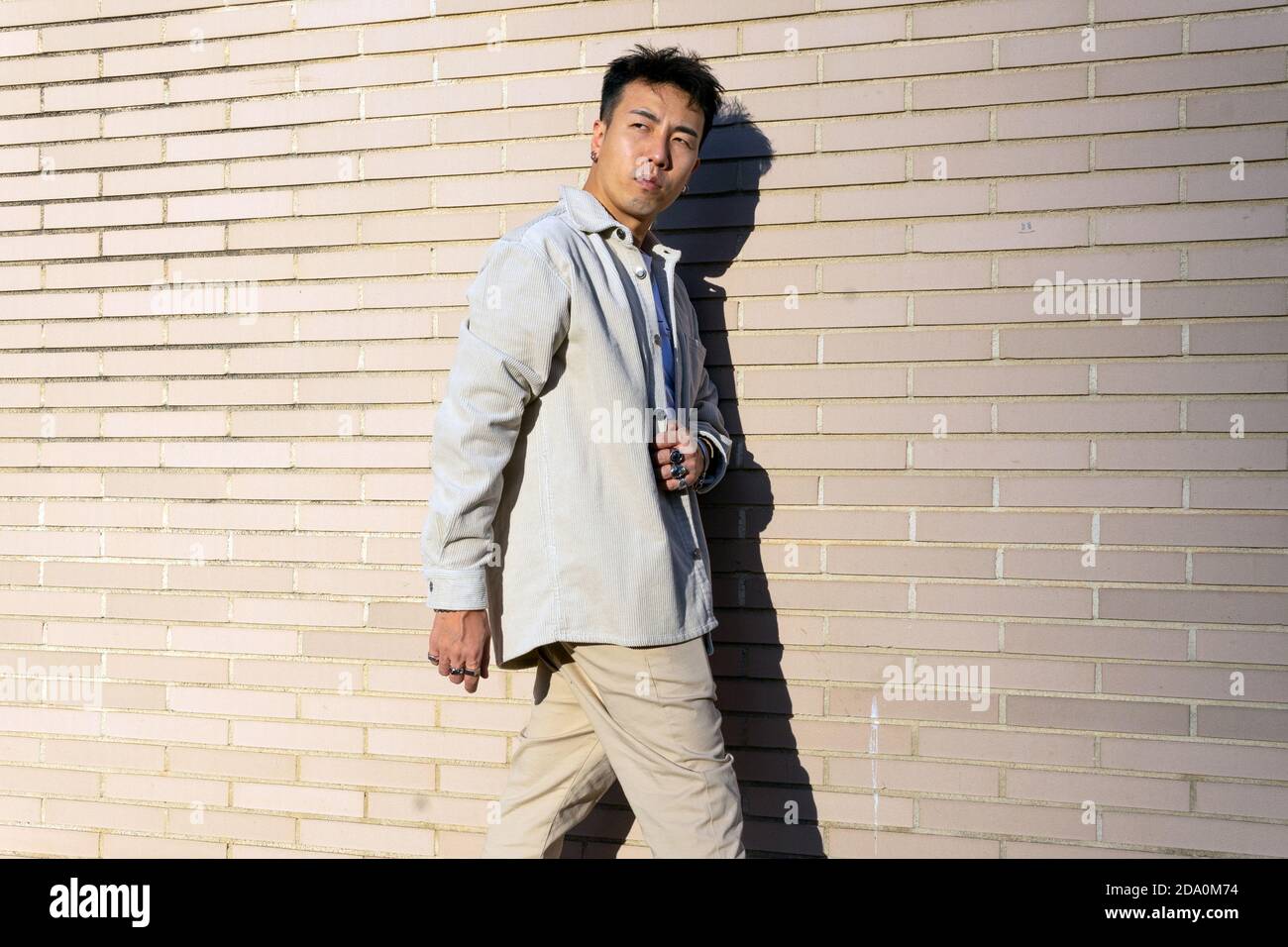 Side view of serious thoughtful Asian male in casual outfit standing ...