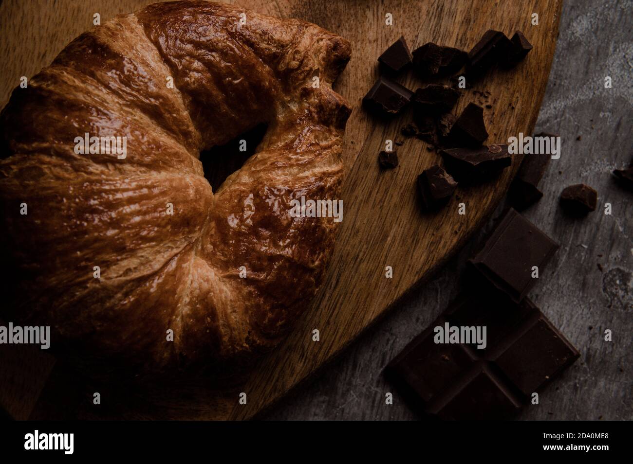 From above of delicious fresh crusty croissant and pieces of dark ...