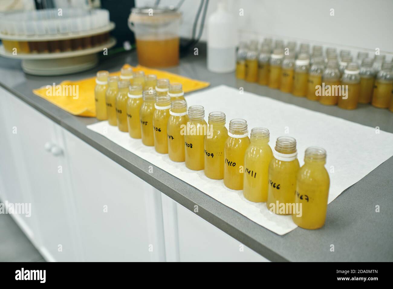 High angle of row of glass bottles with yellow chemical liquid placed ...