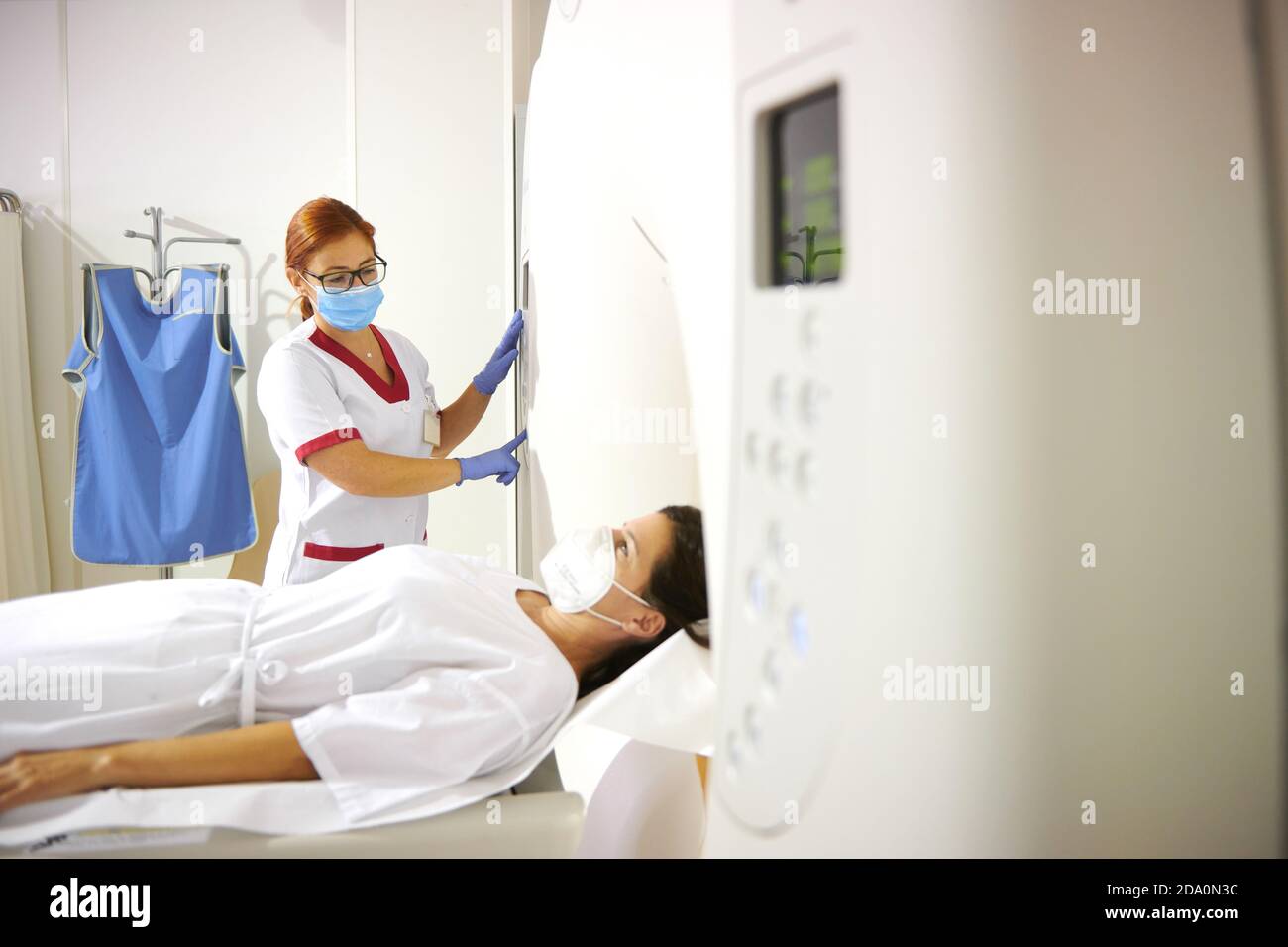 Anonymous doctor in uniform and eyeglasses using tomography machine ...