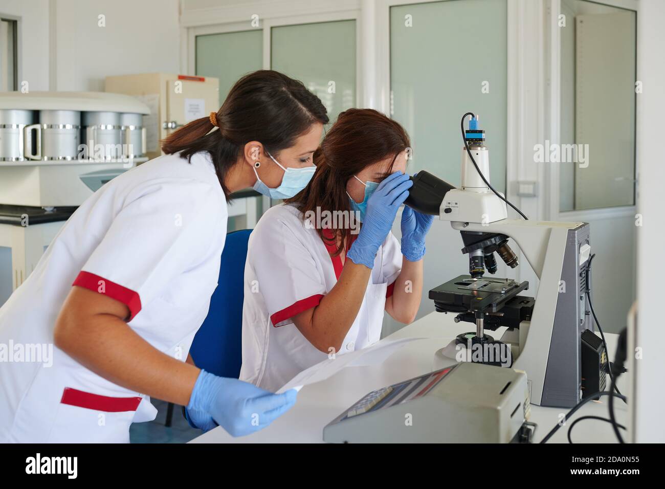 Unrecognizable female medical technologists in uniforms and sterile ...
