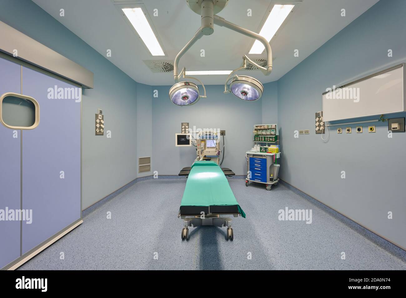 Contemporary operating room interior with couch under shiny lamps near ...