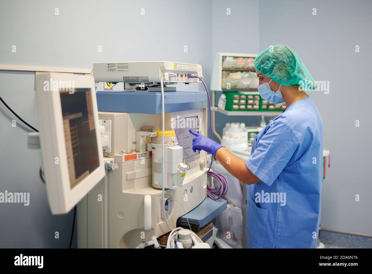Side view of anonymous female medic in uniform touching monitor of ...