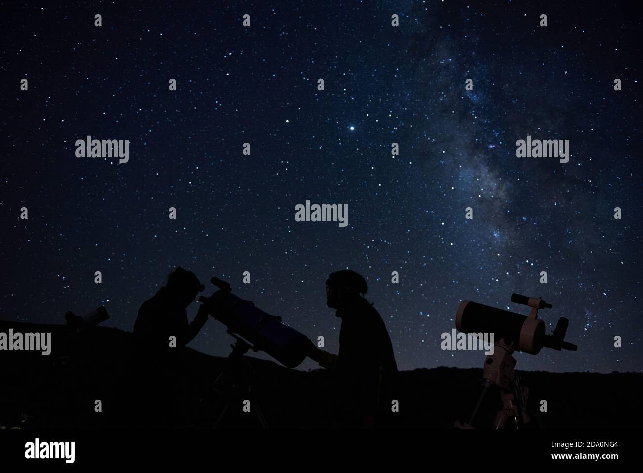 Silhouettes of anonymous scientists using telescopes while exploring ...