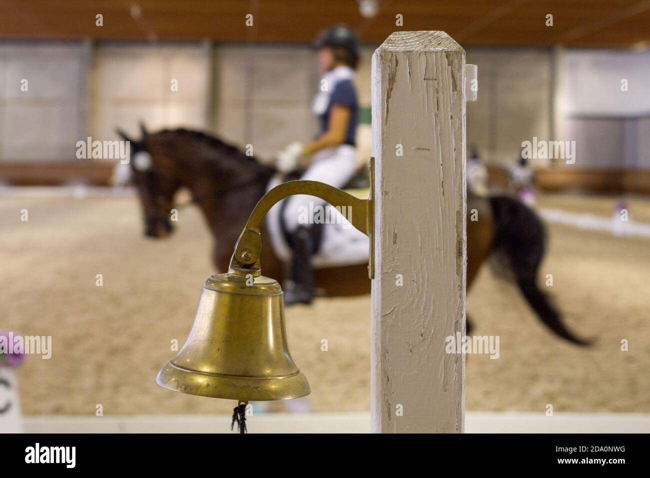 Judge bell with female dressage horse rider in the background riding a ...