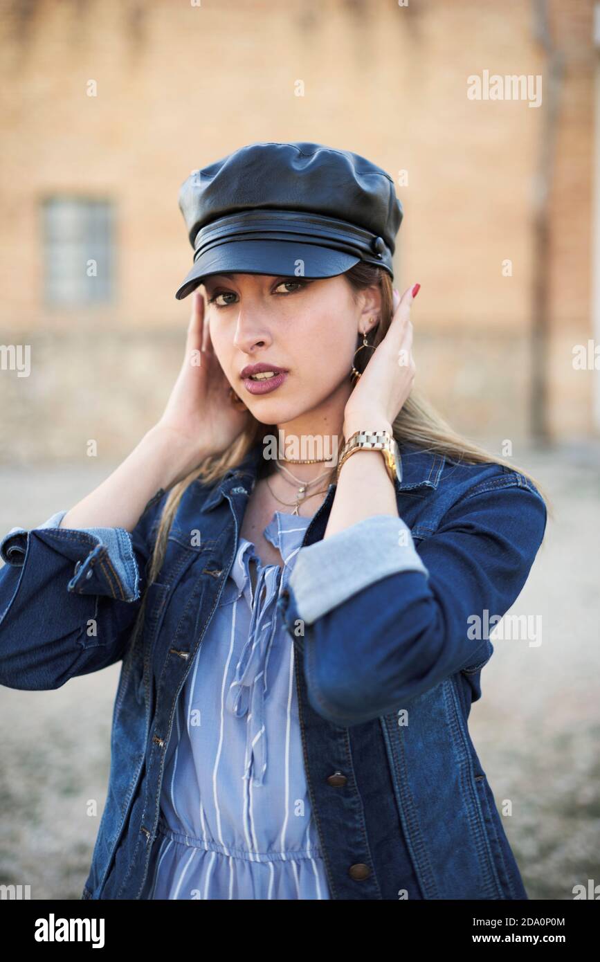 Side view of confident female wearing denim jacket and trendy leather ...