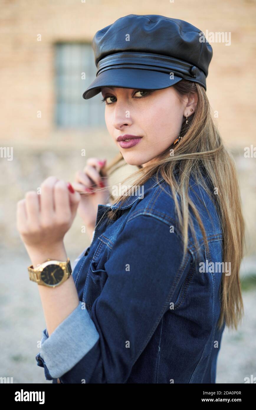 Side view of confident female wearing denim jacket and trendy leather ...