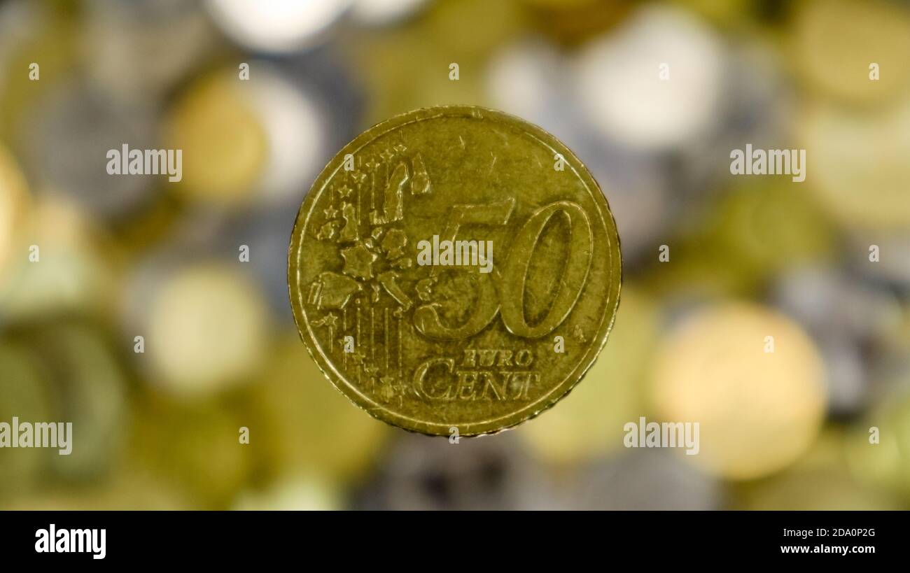 A close-up shows one 50 euro cent coin. This is money. Blurred money ...