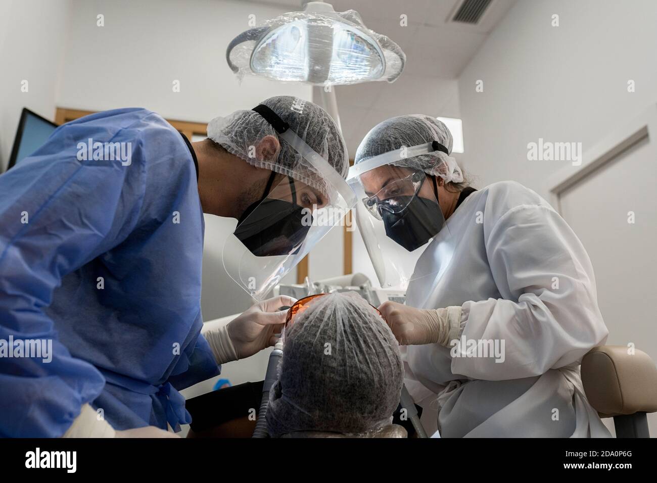 Professional stomatologist with assistant wearing protective masks and ...