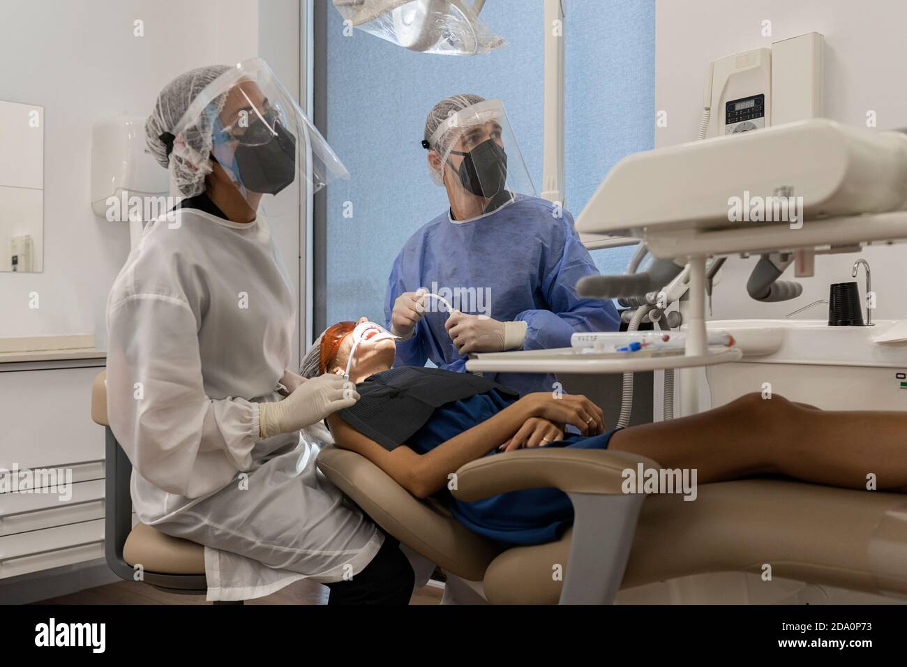 Professional stomatologist with assistant wearing protective masks and ...