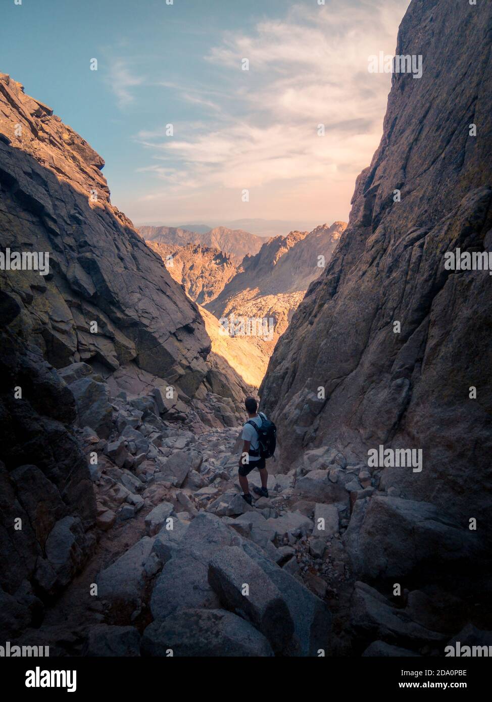 From above back view of unrecognizable male tourist with rucksack ...