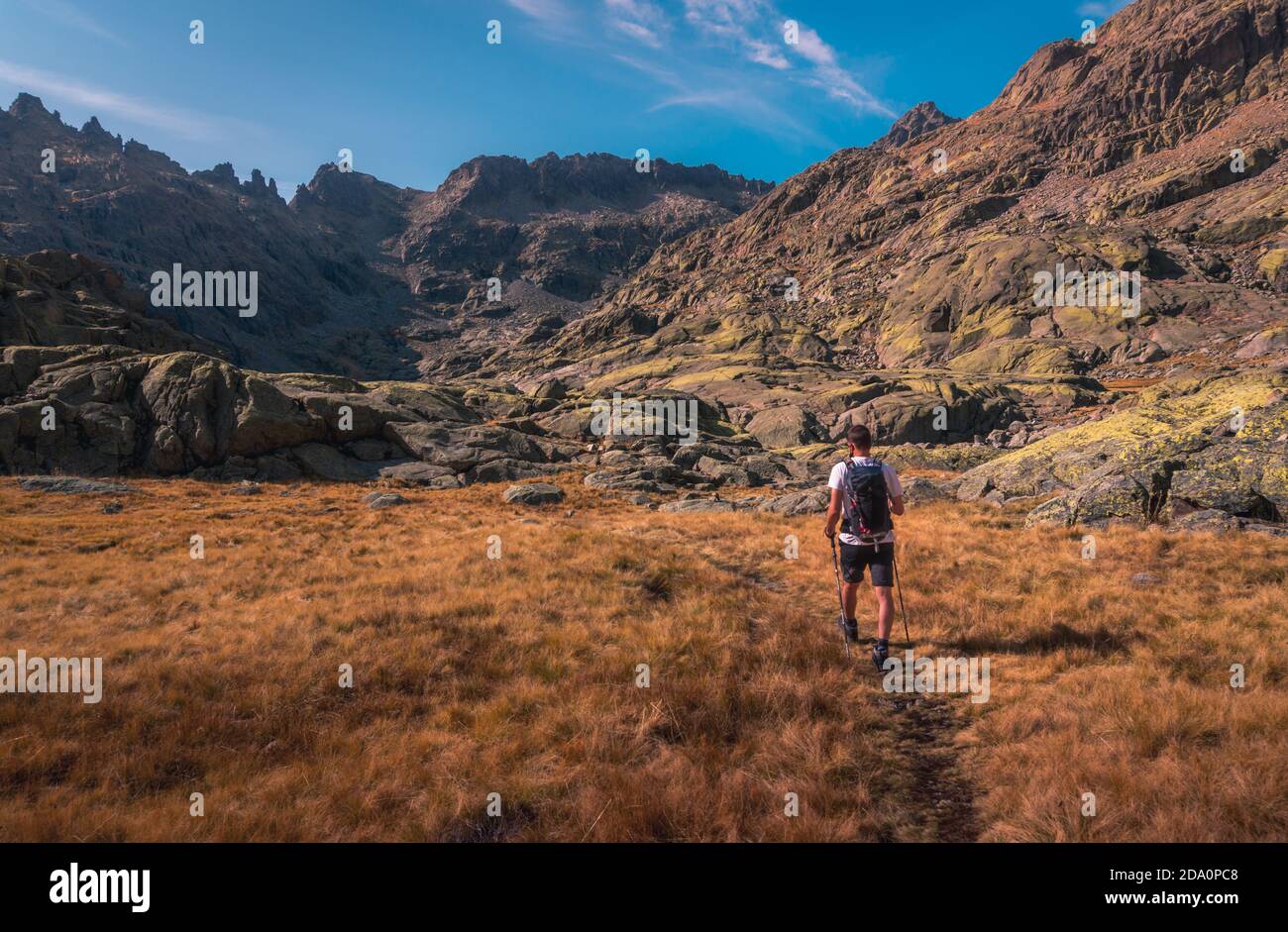 From above back view of unrecognizable male tourist with rucksack ...