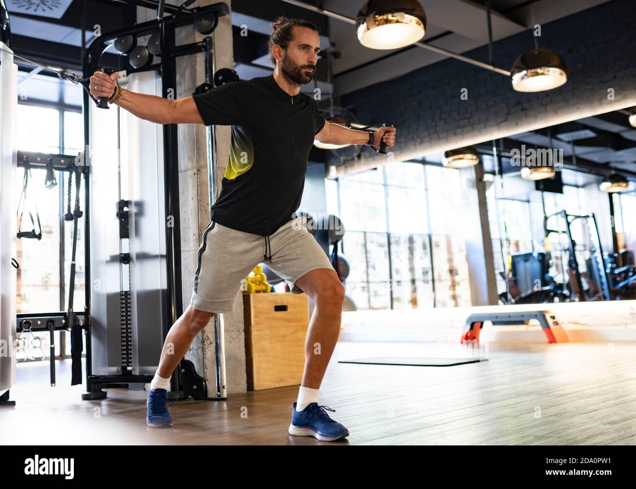 Side view of strong male lifting heavy weights on exercise machine ...