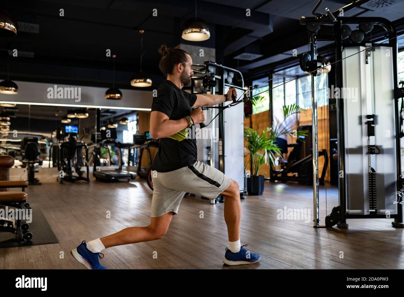 Side view of strong male lifting heavy weights on exercise machine ...