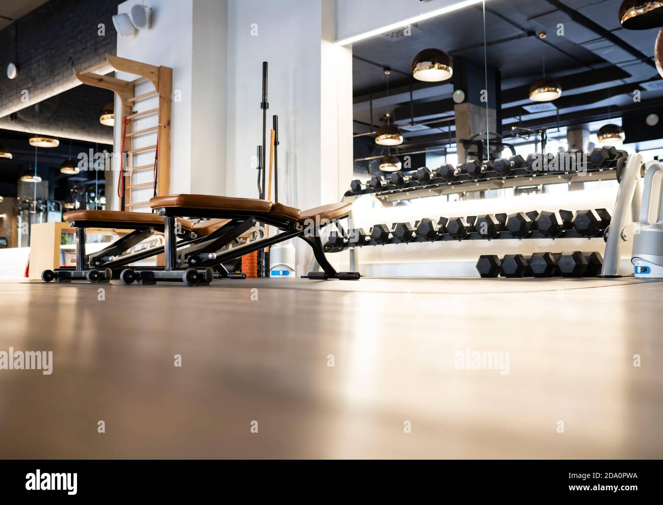 Leather benches and rack with various dumbbells located inside ...