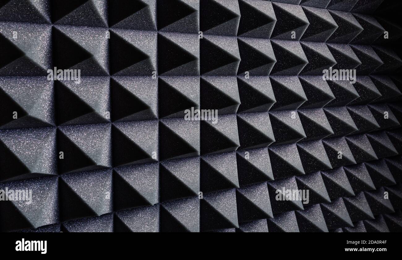 Textured background of wall with black geometric soundproof foam with ...