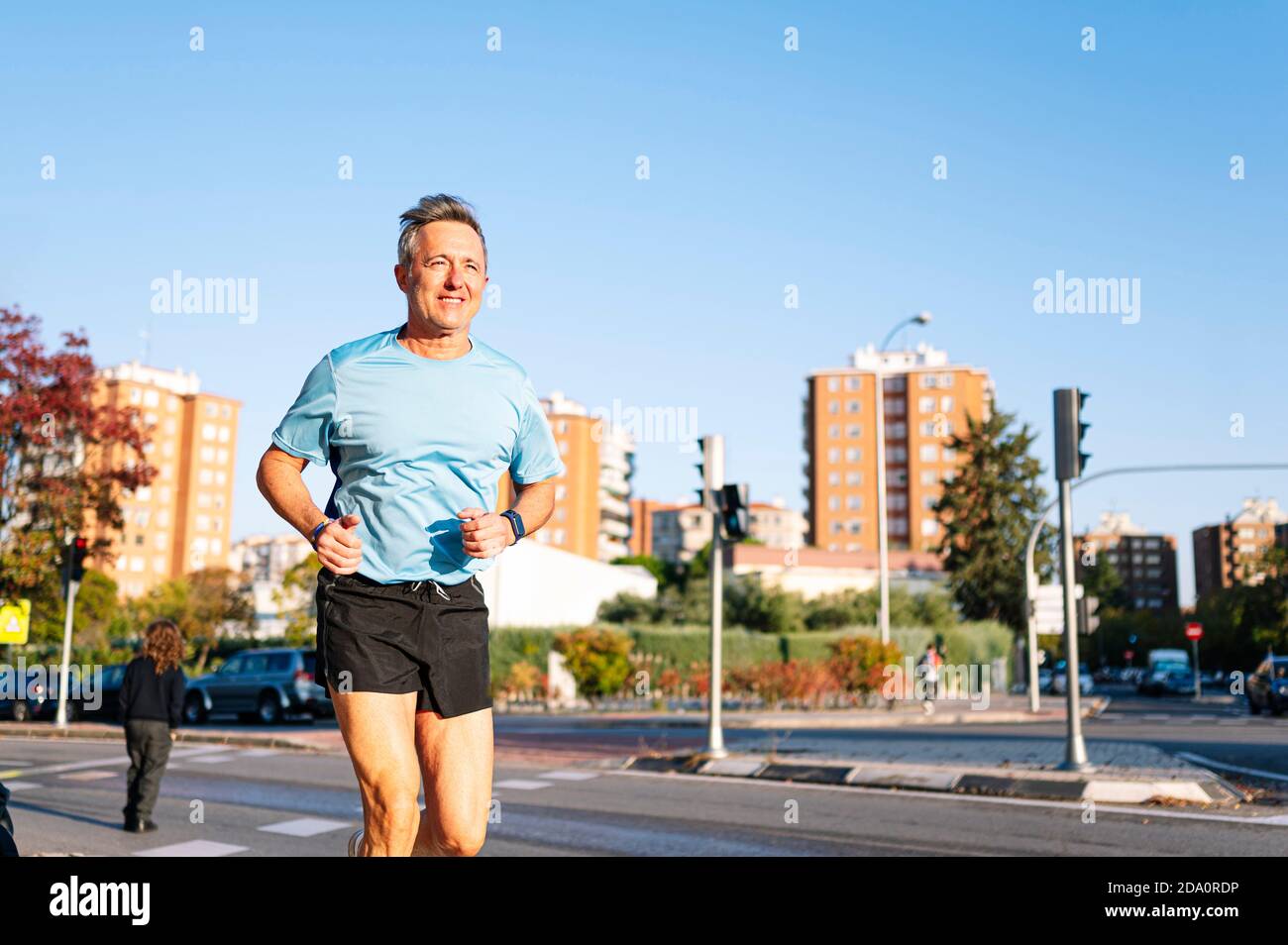 Senior retired man running through the city Stock Photo - Alamy