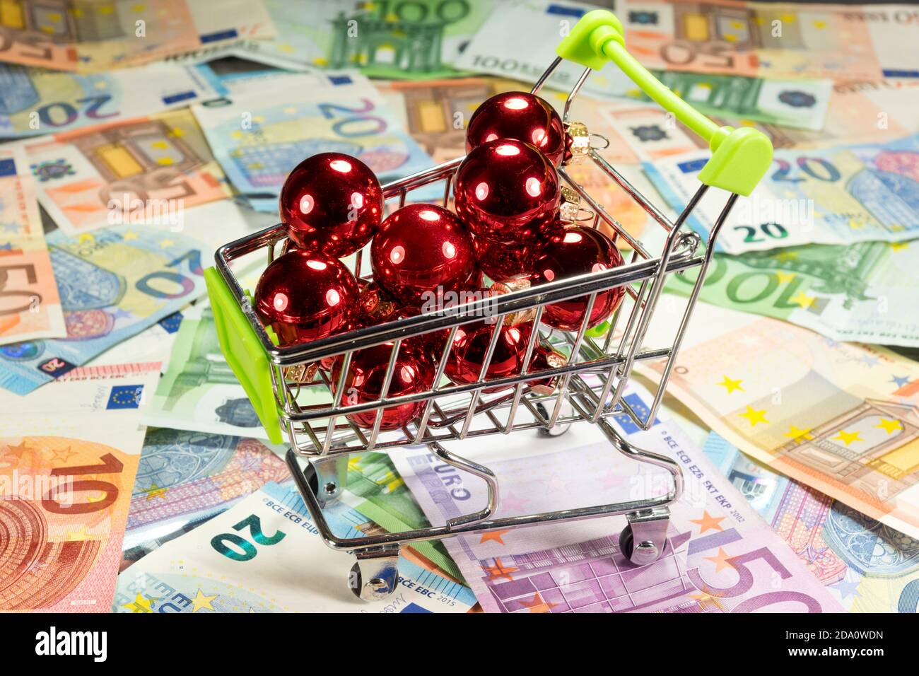 Christmas balls in a shopping cart and money Stock Photo - Alamy