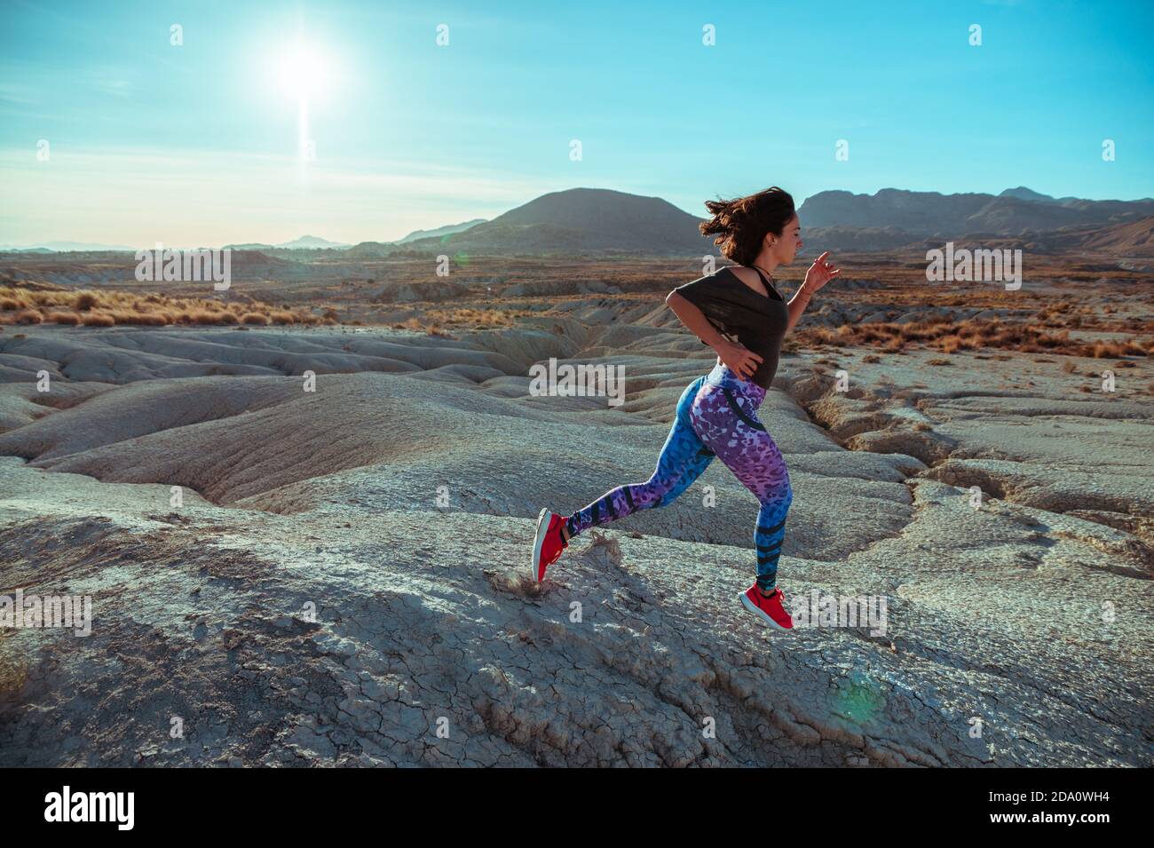 Full body side view of active female athlete in sportswear running and ...