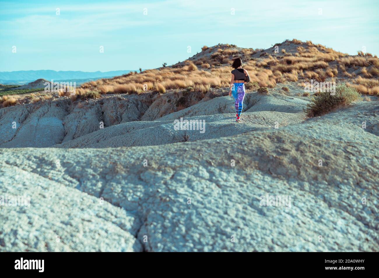 Back view of unrecognizable active female athlete in sportswear walking ...
