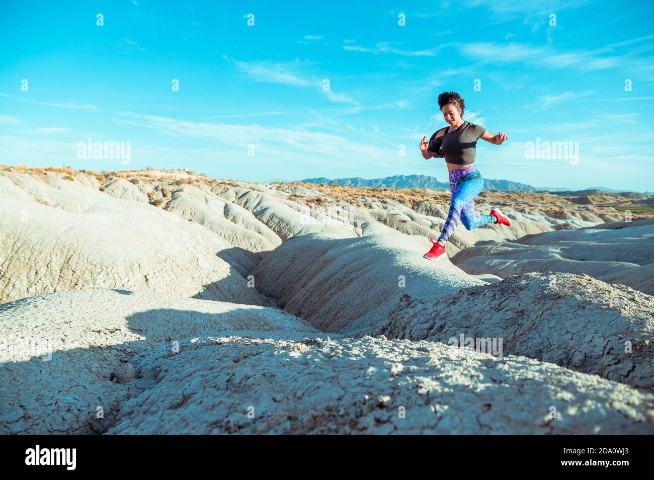 Full body side view of active female athlete in sportswear running and ...