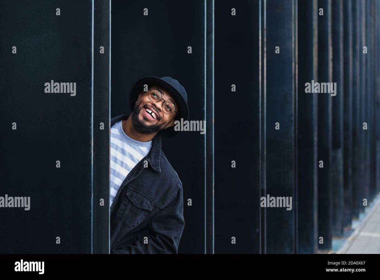 Anonymous ethnic male in denim jacket hiding face with reached arm ...