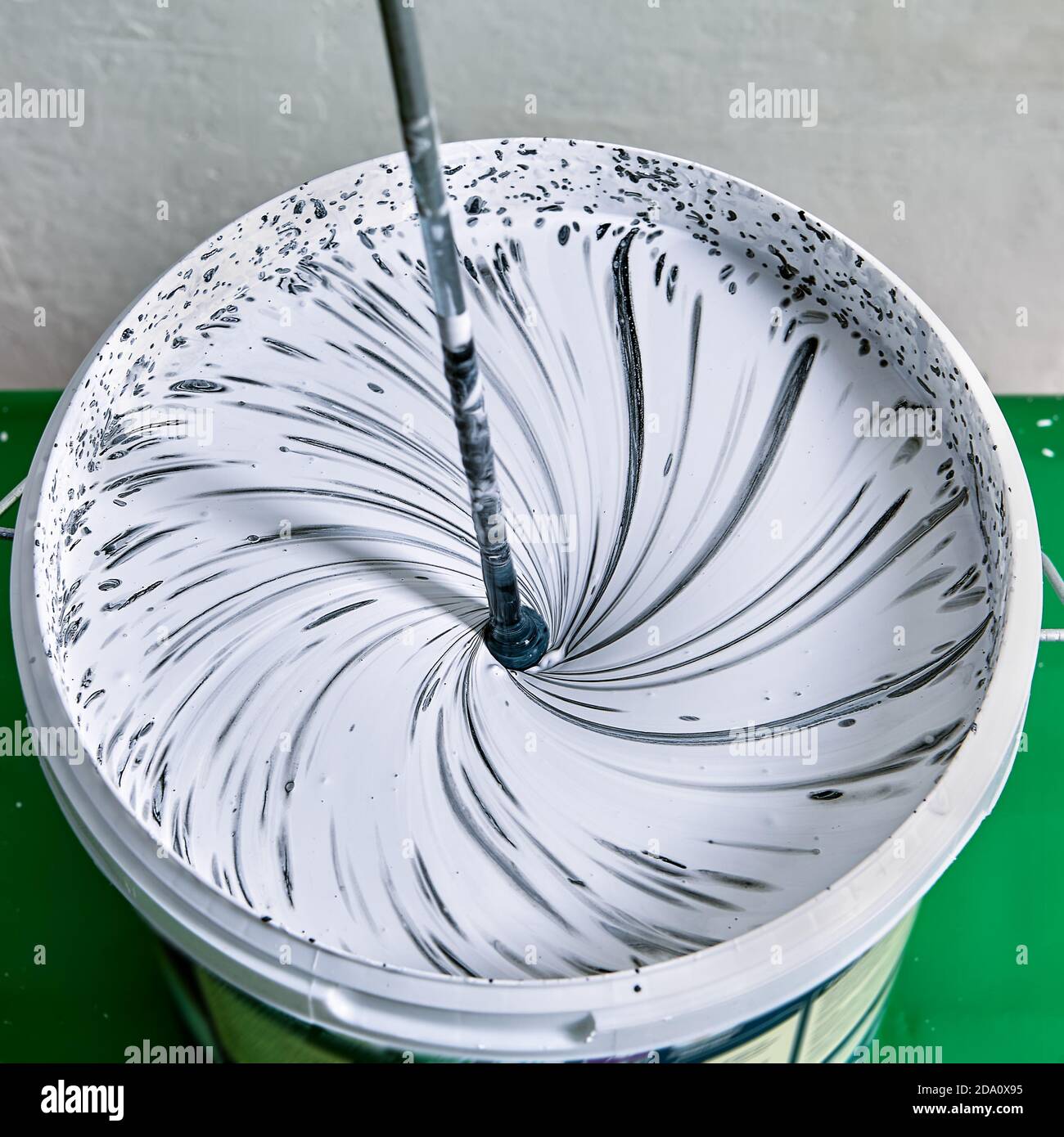 Painter combines paints for making color for painting walls with paddle ...