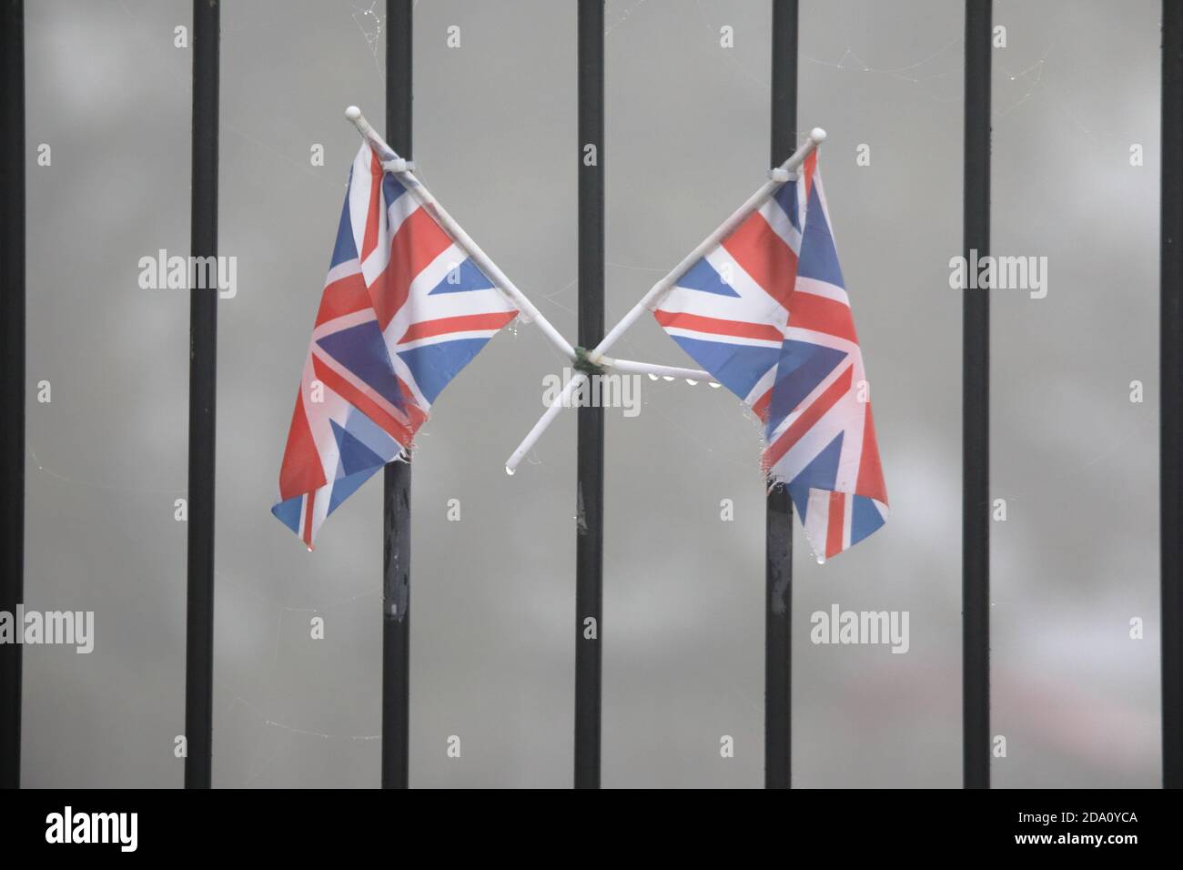 a crossed pair of union jack flags attached to vertical black railings ...