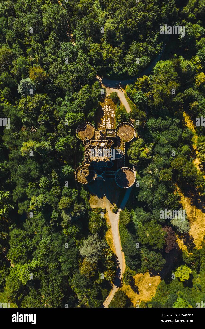 Aerial view of aged stone building surrounded by lush green woods near ...