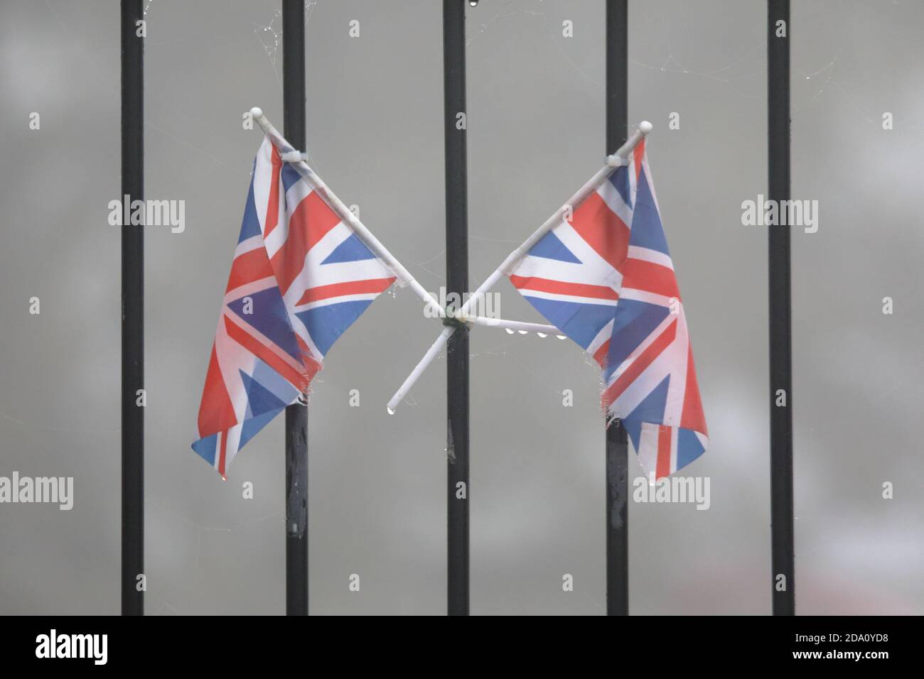 a crossed pair of union jack flags attached to vertical black railings ...