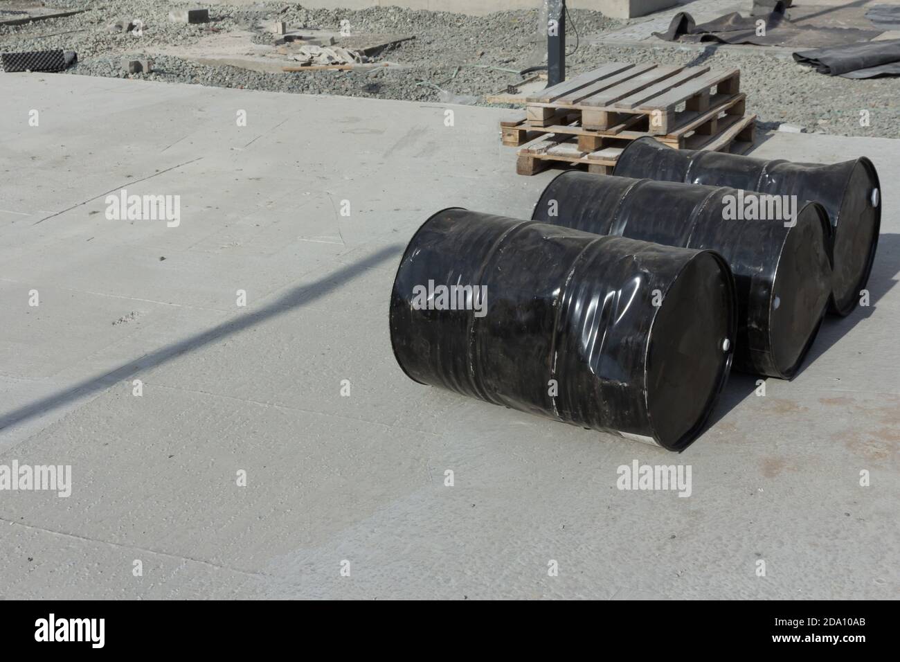 Black barrels for storing liquids. Construction barrels Stock Photo - Alamy