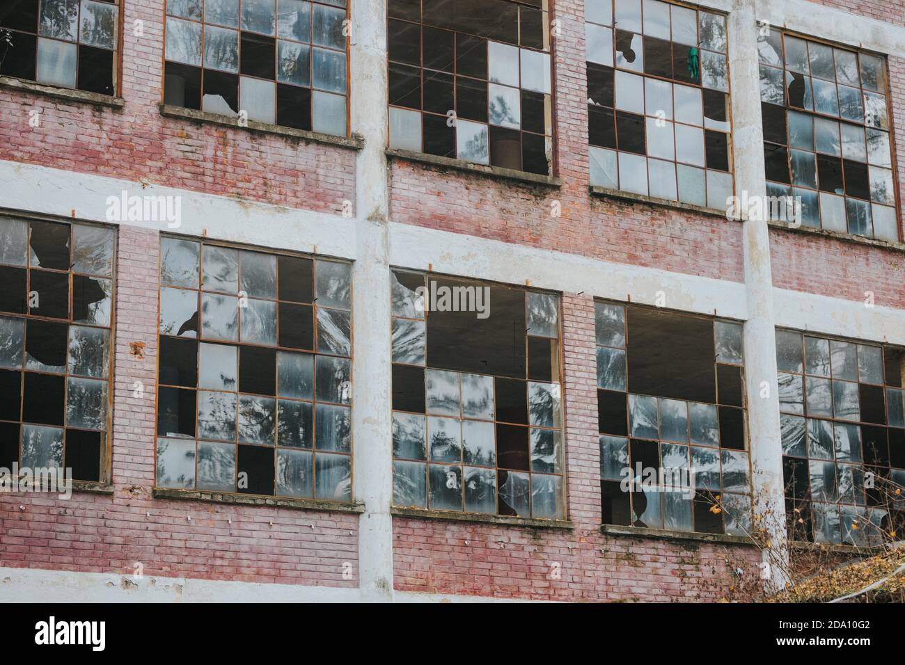 View of broken windows in an old abandoned brick building Stock Photo - Alamy