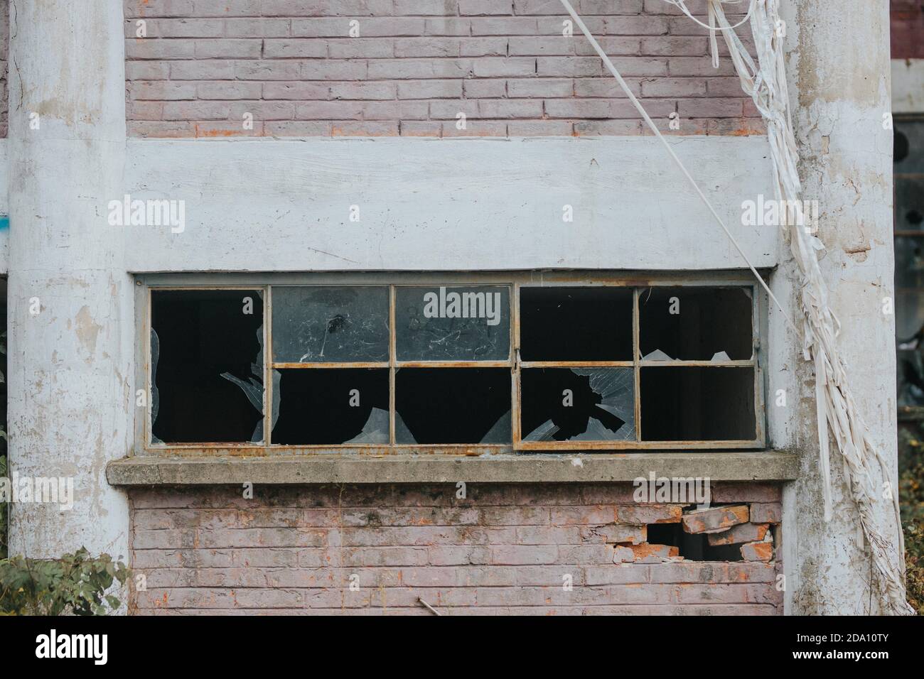 View of broken windows in an old abandoned brick building Stock Photo - Alamy