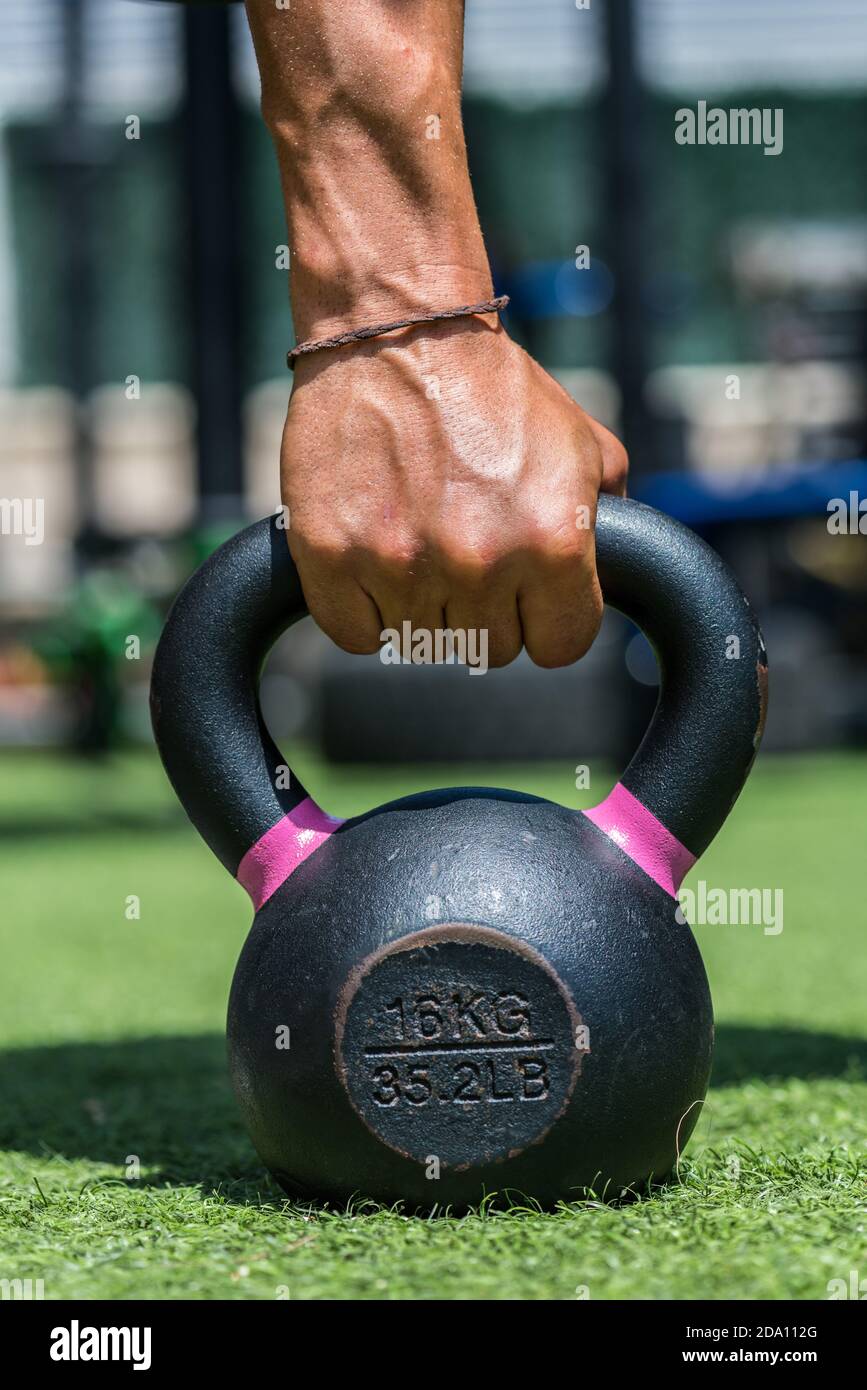 Athlete with strong body doing exercises with heavy metal kettlebell ...