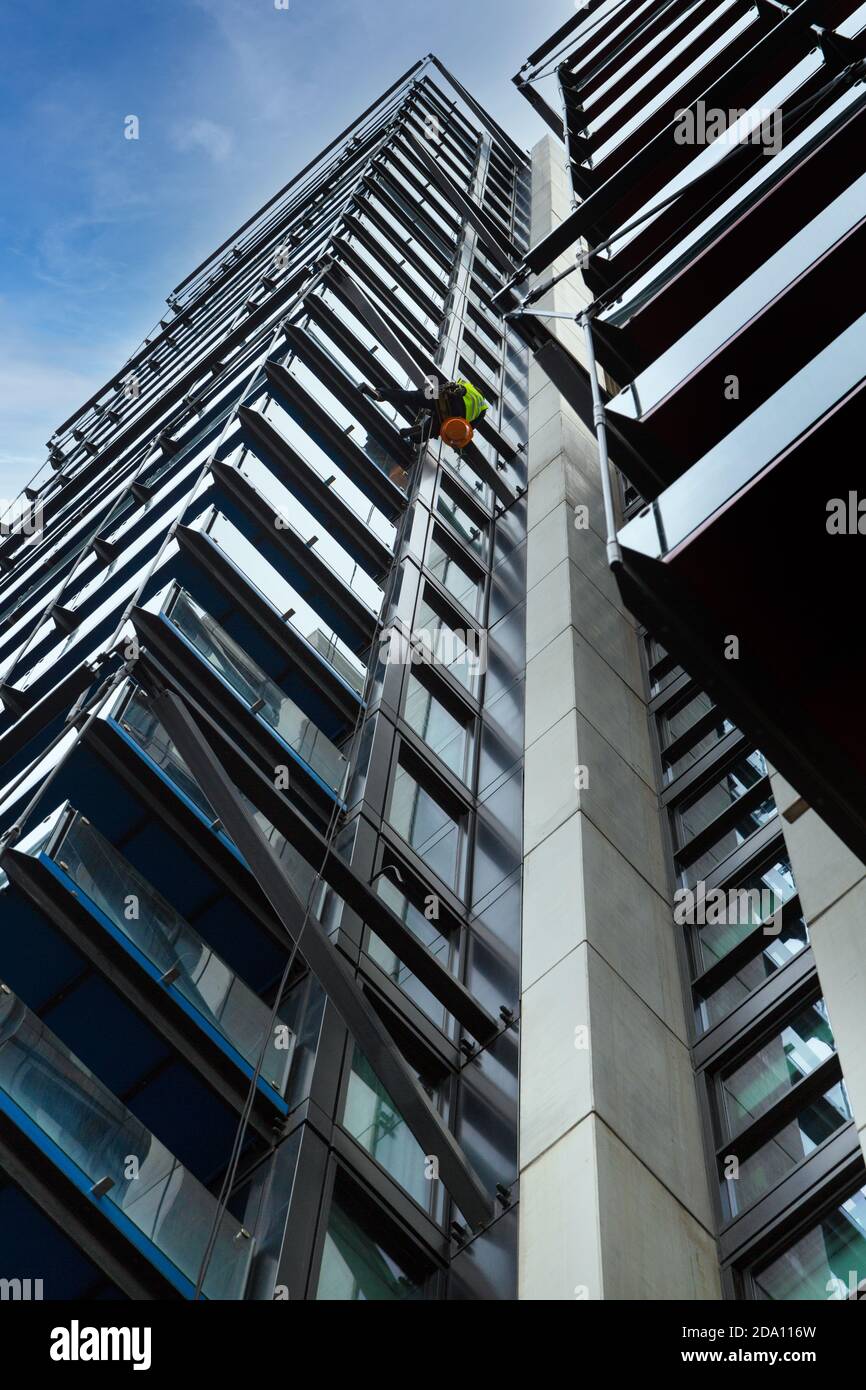 Window cleaner working at height, climbing tower block, london, uk ...