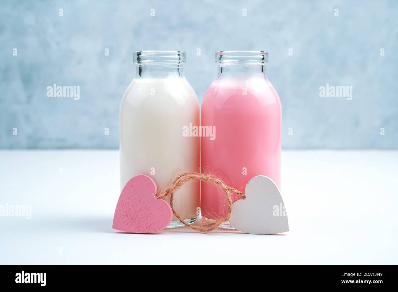 Two bottles of milk drink of different colors and two tied hearts ...